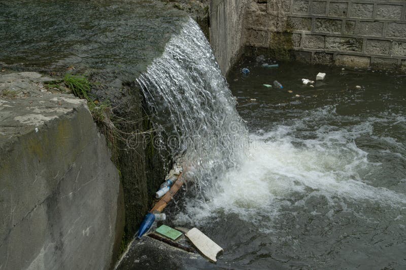 Small Waterfall Cascading into Polluted Water Filled with Plastic Waste ...