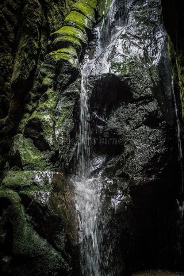 A Small Waterfall Falling from the Green Rocks Stock Image - Image of ...