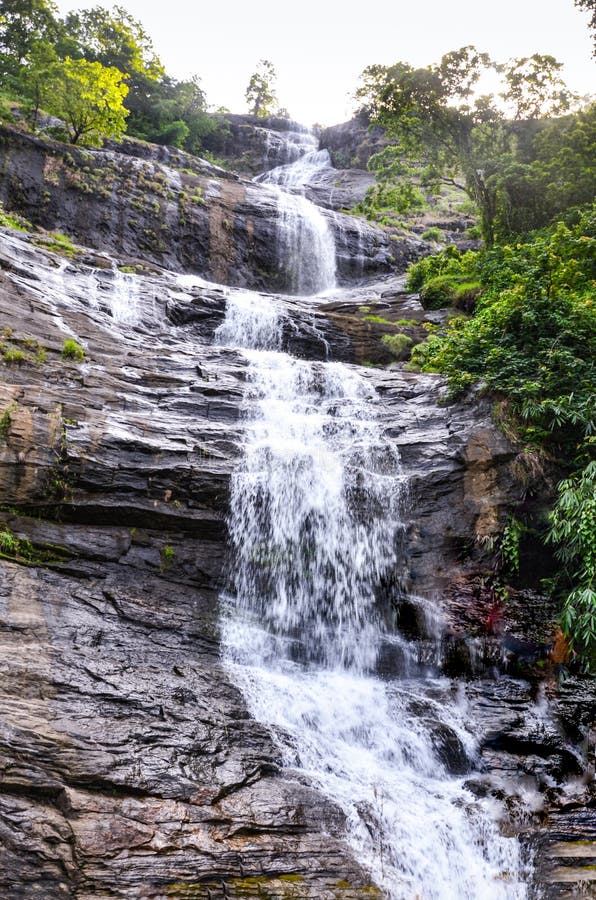 Small Waterfall Over the Rocks in a Green Forest Hill Stock Photo ...