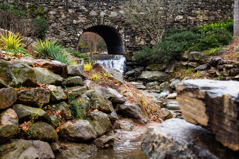 A Small Waterfall with a Stream Next To a Stone Wall Stock Image ...