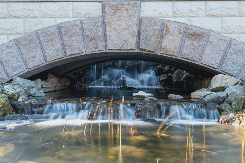 A Small Waterfall Under a Bridge Stock Photo - Image of stream, river ...