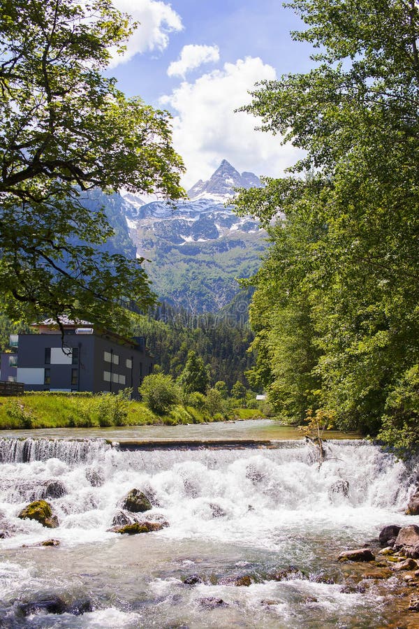 A Small Waterfall in the Village Against the Backdrop of the Alps Stock ...