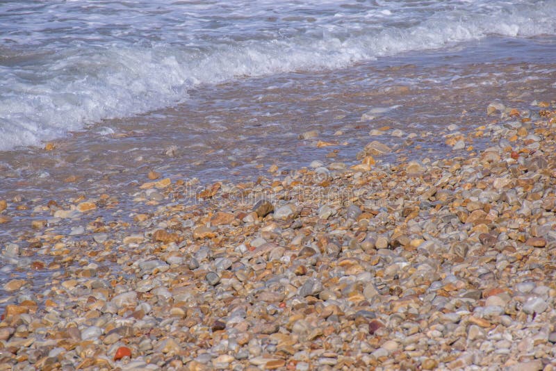 A Small Wave with Foam Rolls on the Sea Pebbles Stock Image - Image of ...