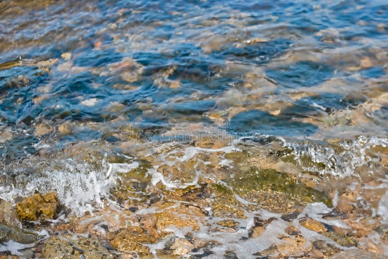 A Small Wave Rolls on the Seashore. Multi-colored Stones Underwater ...