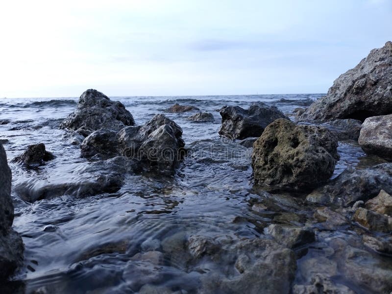 The Small Waves Hit the Rocks with the Blue Sky Background. Stock Image ...
