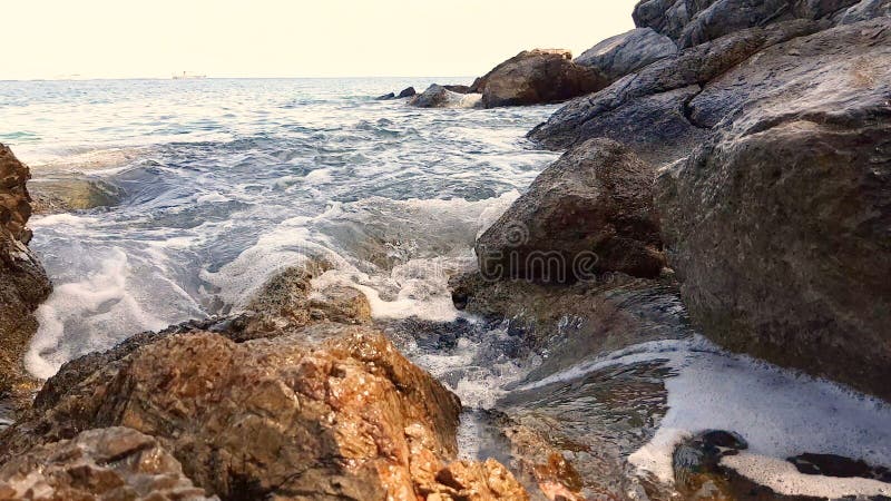 Small Waves Splashing on the Rocks at Sunset. Stock Image - Image of ...