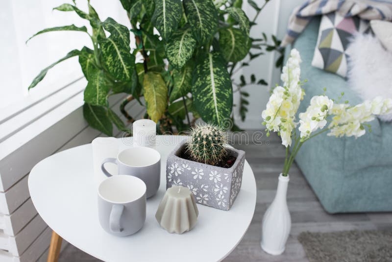 A Small White Coffee Table with a Cactus, a Gray Candle and Cups. Stock ...