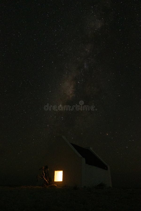 A Small White Hut is Lit from within Underneath the Milky Way in the ...