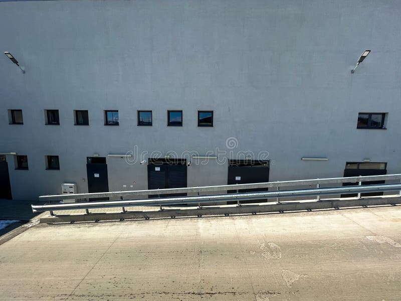 Small Windows and Exit Doors on Industrial Building Behind Concrete ...