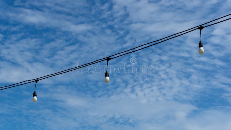 A Small Wired Lamp Bulb with Blue Sky in the Background Stock Photo ...