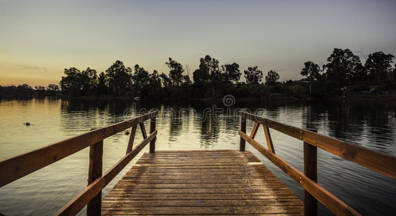 Small Wooden Dock with Fences on a River Surrounded by Trees during the ...