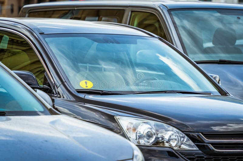 Small Yellow Beginner Driver Sign Sticker on the Windshield of a Parked ...