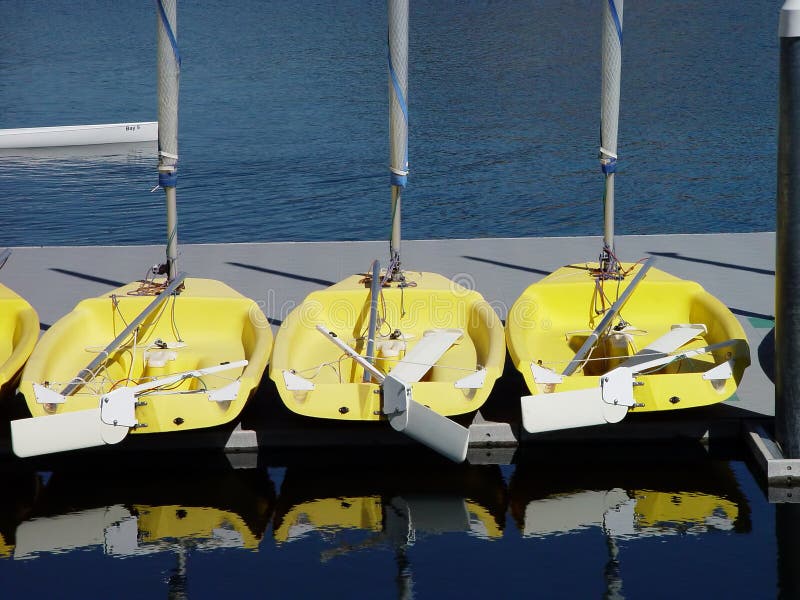 Small Yellow Sail Boats Sitting on Dock Stock Photo - Image of booms ...