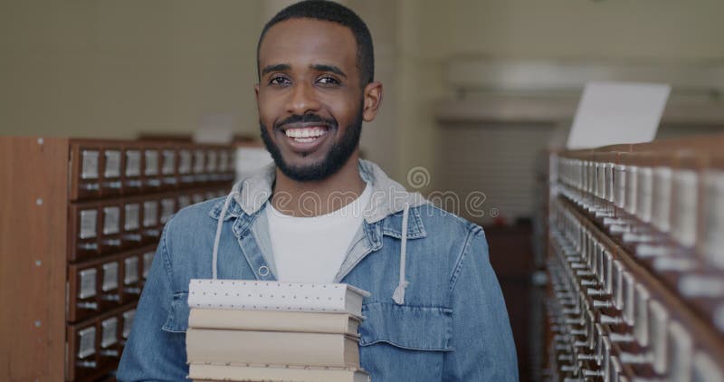 Smart African American Student Standing in University Library Holding ...