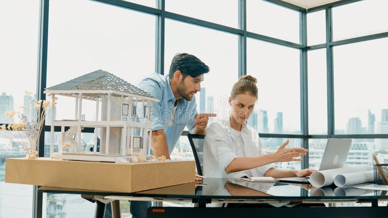 Smart Engineer Inspect House Model while Colleague Using Laptop ...