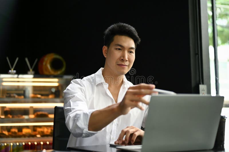 Smart Asian Businessman Remote Working in a Coffee Shop, Using His ...