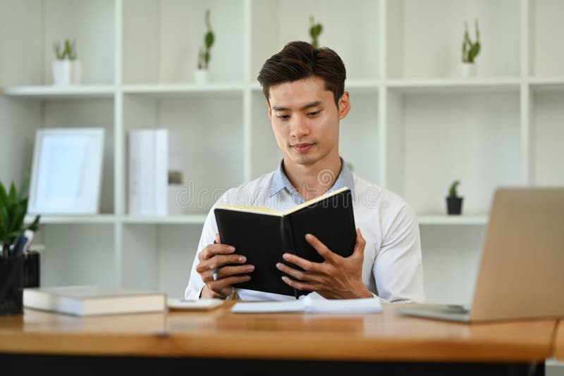 Smart Asian Male Manager Analyzing Weekly Schedule in His Notebook ...