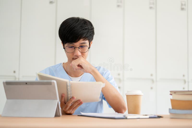 A Smart Asian Male Medical Student is Focused on Reading a Textbook or ...