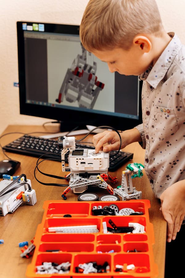 Smart Boy Dressed in Gray Shirt Makes a Robot from the Robotic ...