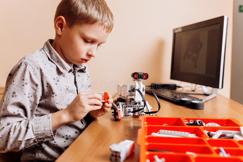 Smart Boy Dressed in Gray Shirt Makes a Robot from the Robotic ...