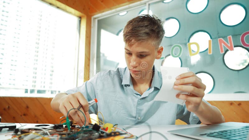 Boy Inspect or Learn To Use Electronic Tool while Looking at Note ...