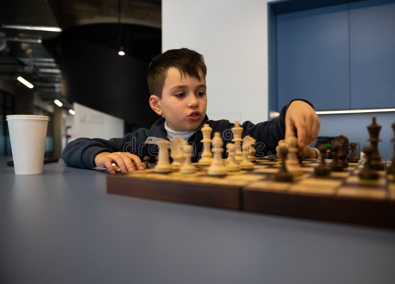 Intellectual Schoolboy Plays Chess, Moves a Chess Piece on Checkerboard ...