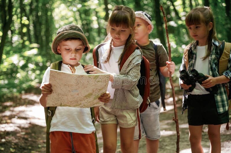 Smart Boy is Reading the Map. Kids in Forest at Summer Daytime Together ...