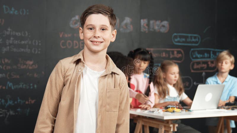 Smart Boy Smiling at Camera while Diverse Friend Working at Board ...