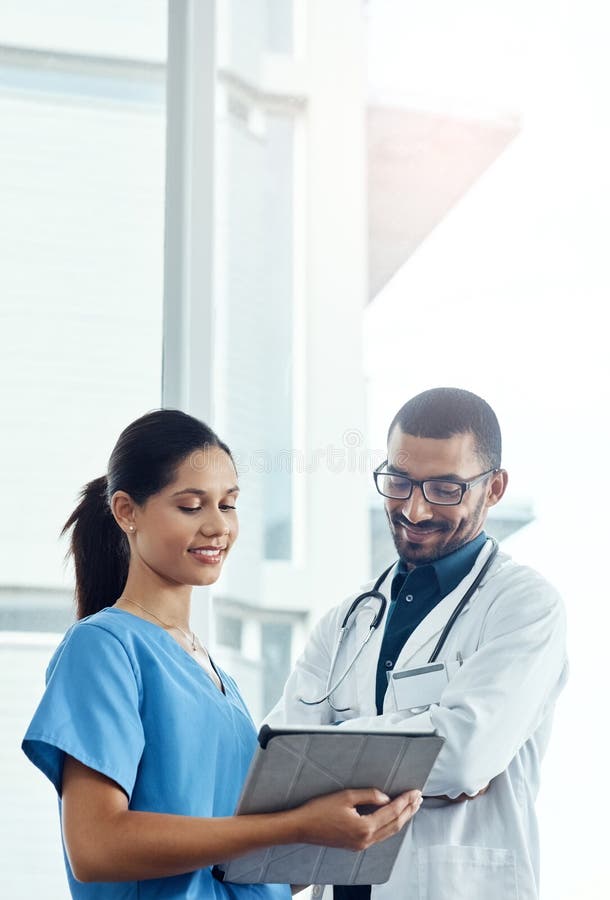 Smart Doctors Use Smart Technology. Two Young Doctors Using a Digital ...