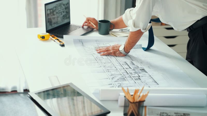 Smart Engineer Standing and Writing Idea at Blueprint and Laptop ...