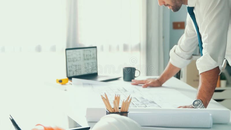 Smart Engineer Standing and Writing Idea at Blueprint and Laptop ...