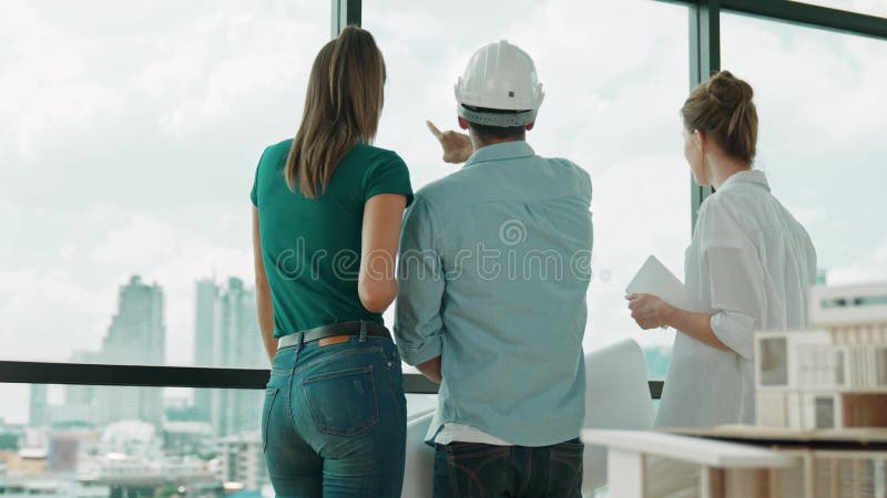 Smart Engineer Team Talking while Look at Skyscraper. Back View ...