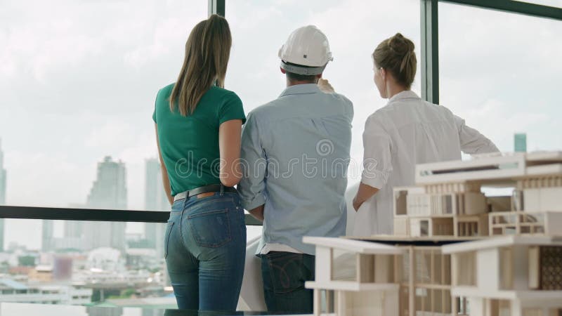 Smart Engineer Team Talking while Look at Skyscraper. Back View ...