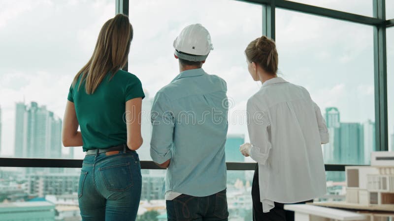 Smart Engineer Team Talking while Look at Skyscraper. Back View ...