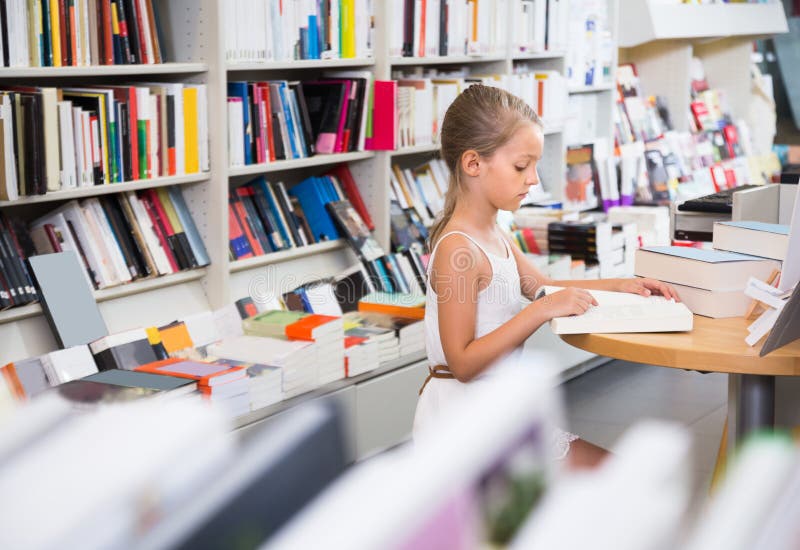 Smart Girl Child is Engaged with a Book in the Library Stock Image ...