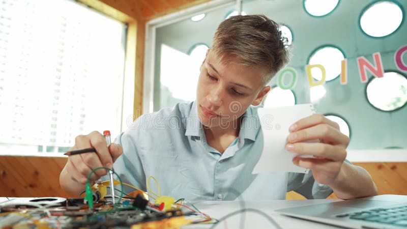Boy Inspect or Learning To Use Electronic Tool while Taking a Note ...