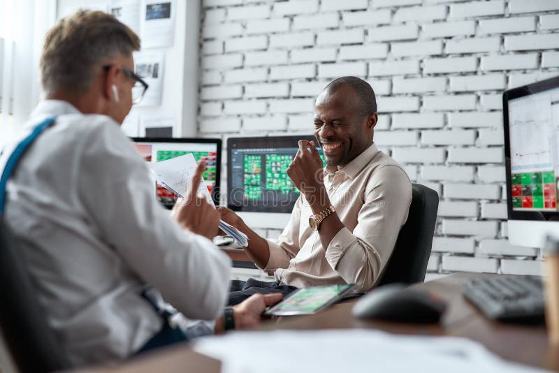 Smart Ideas. Two Diverse Colleagues Traders Discussing Plans while ...