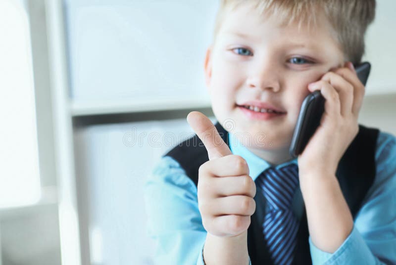 Smart Little Boy in Suit Working on Computer, Taking Notes and Speaking ...