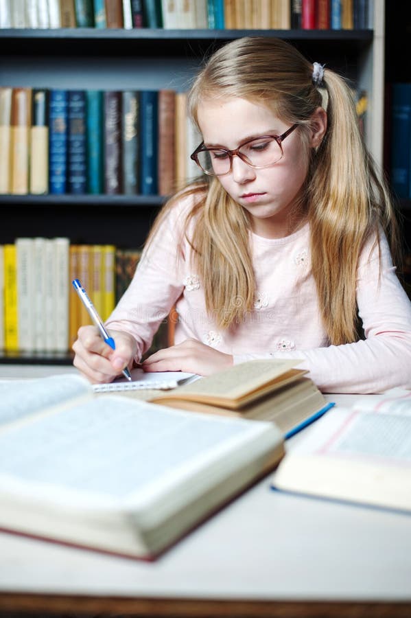 Smart Little Girl with Glasses Writing on Book, Stock Image - Image of ...