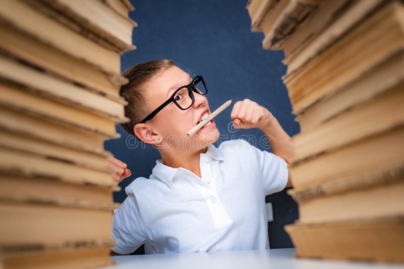Smart Looking Boy Holding Pencil in His Mouth, Looking Away and Stock ...