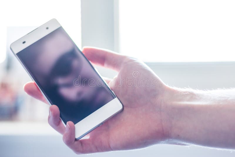 Smart Phone in the Hand, Reflection of a Face on the Black Display ...