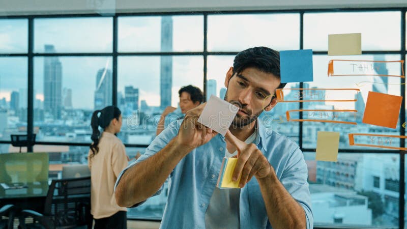 Manager Writing Sticky Notes at Glass Wall To Planing Strategy. Tracery ...