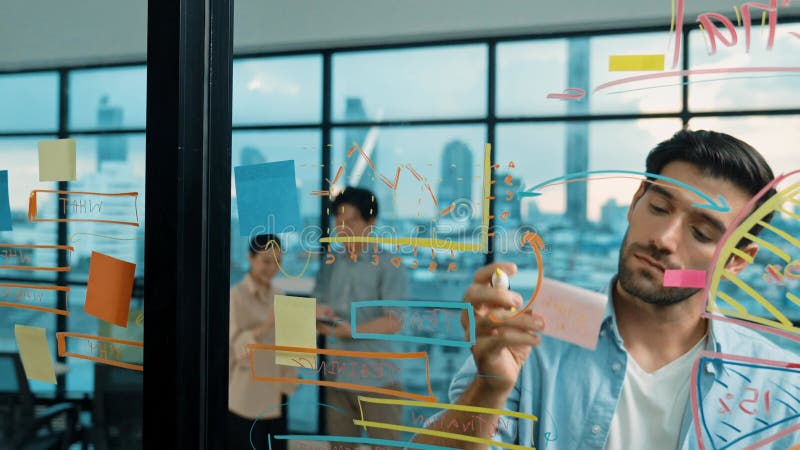 Manager Writing Sticky Notes at Glass Wall To Planning Strategy ...