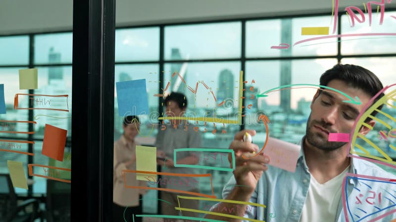 Manager Writing Sticky Notes at Glass Wall To Planning Strategy ...