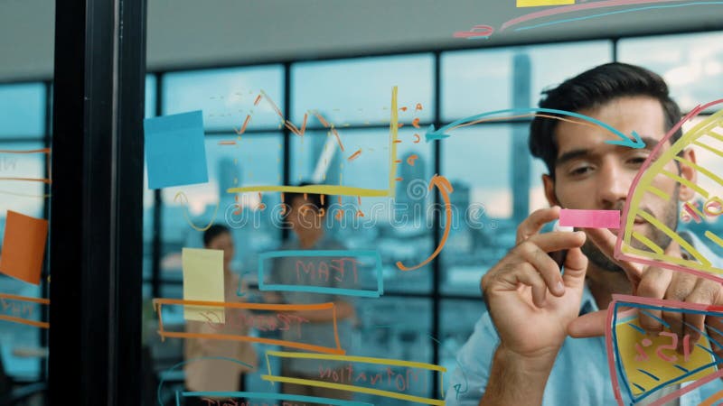 Manager Writing Sticky Notes at Glass Wall To Planning Strategy ...