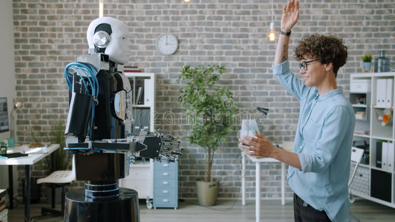 Smart Robot Copying Movements of Young Woman Developer in Modern Office ...