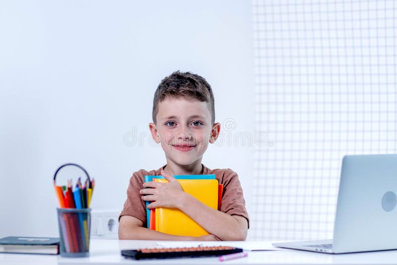 Smart Schoolboy is Ready To Study at a Neat Table in a White Interior ...