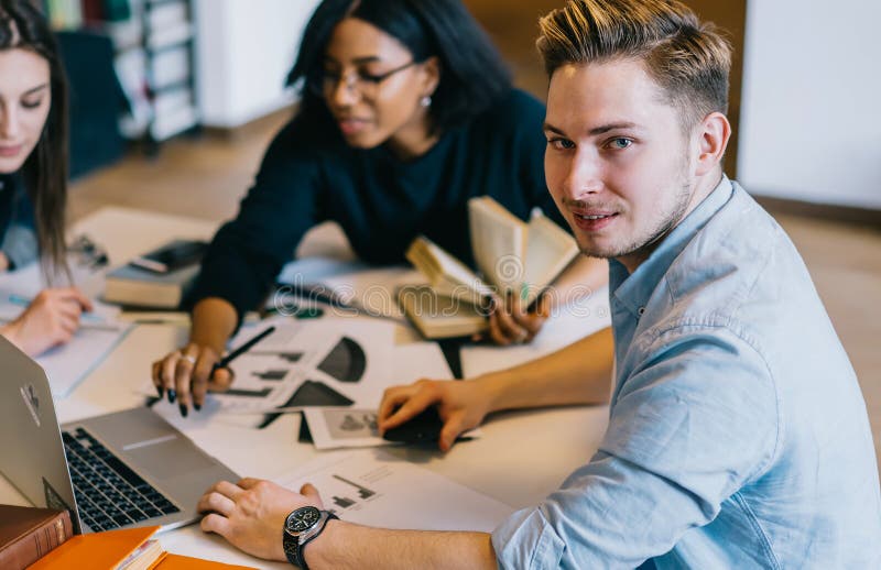 Smart Student Looking at Camera while Multiethnic Women Making Homework ...
