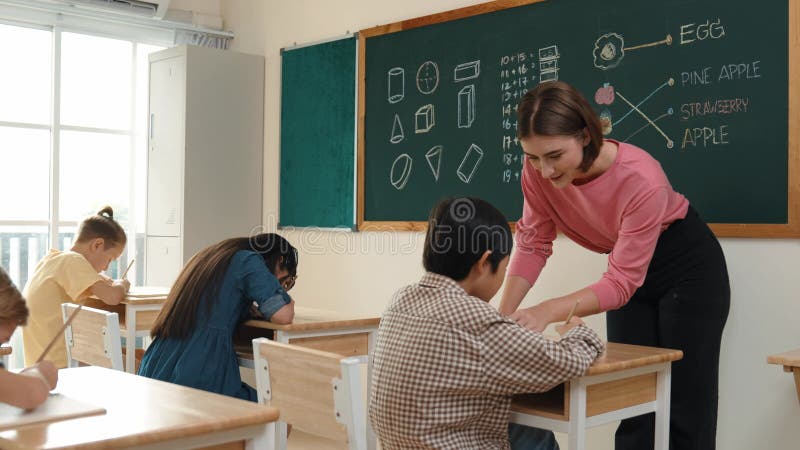 Teacher Checking Cute Student Homework while Explaining Idea at Class ...