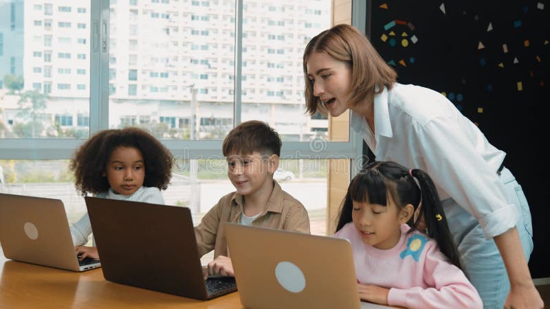 Smart Teacher Teaching and Looking Student Using Laptop at Classroom ...